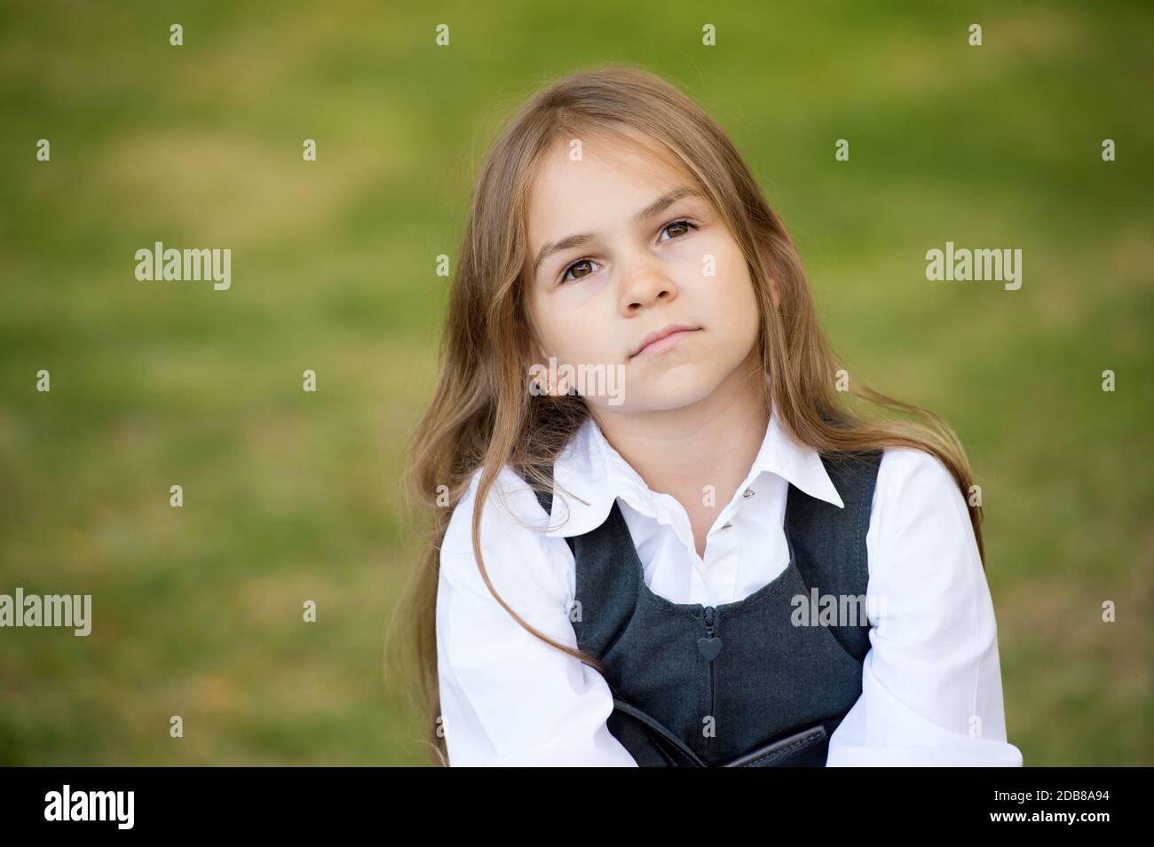 Serious little kid with long hair wear fashion school uniform natural ...