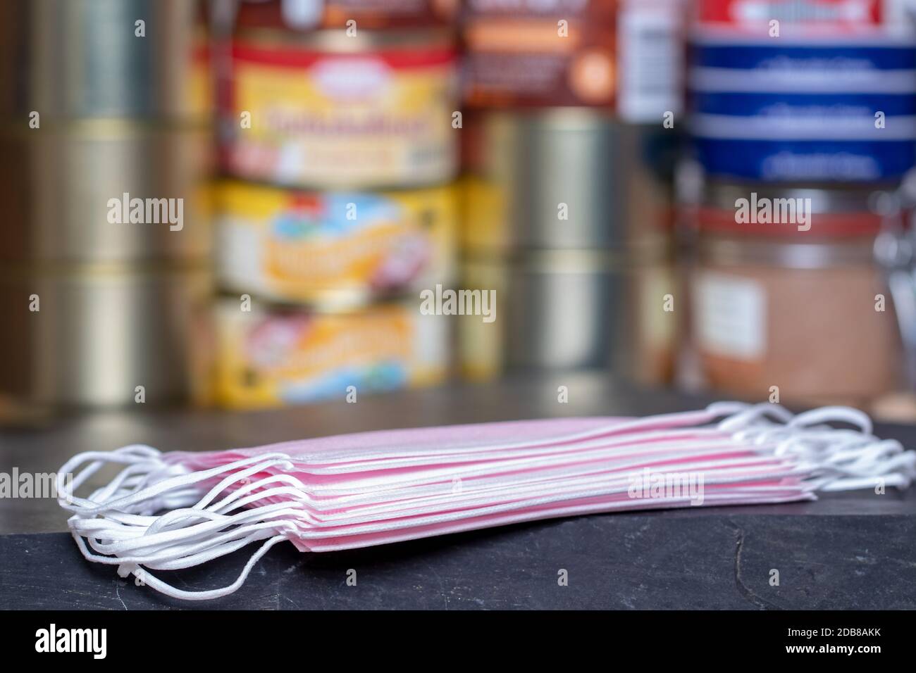 Coronavirus panic concept. Focus on stack of surgical masks on table ...