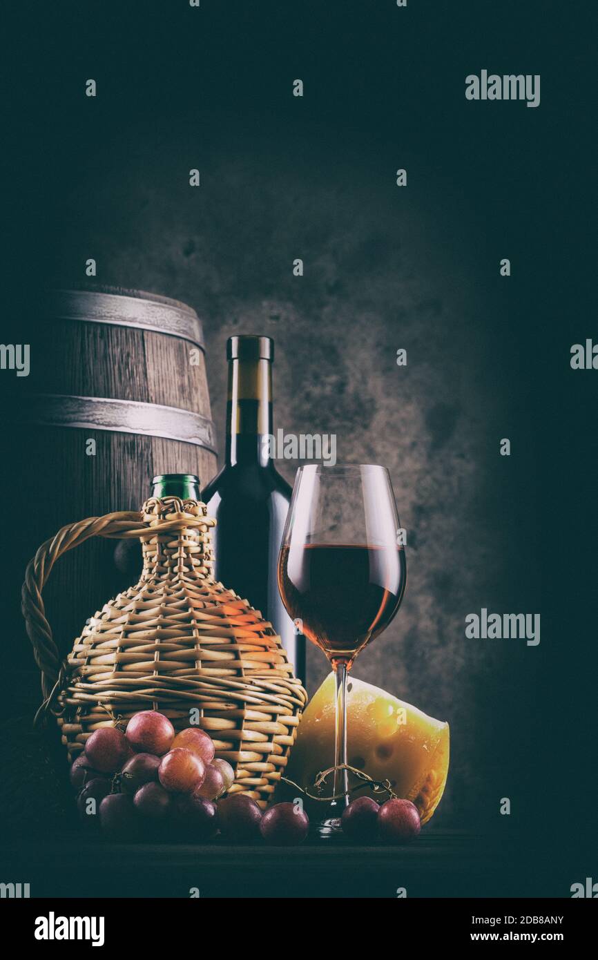 Wine still life with a barrel and red wine with grapes. Vintage toning ...