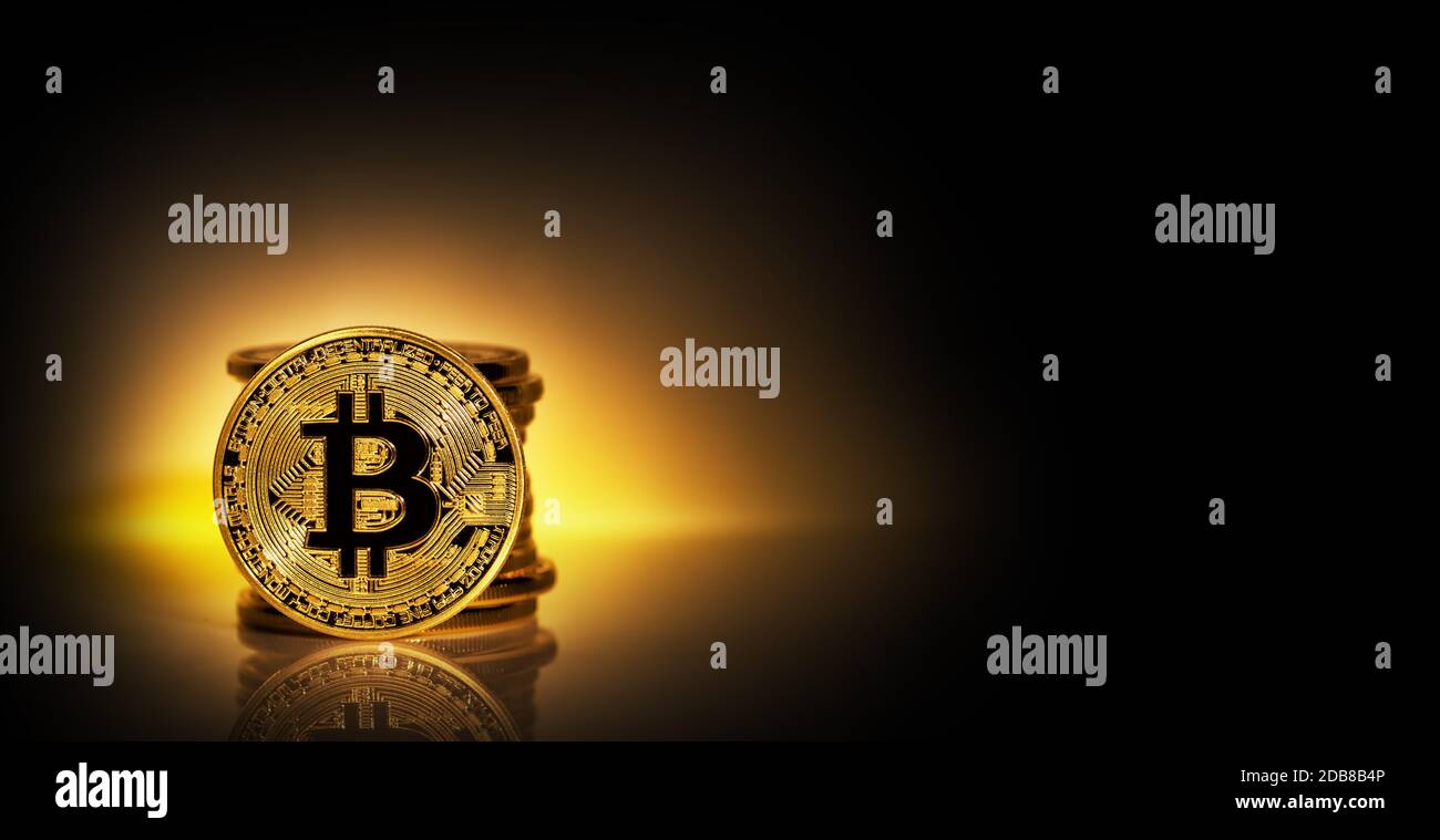 Virtual currency bitcoin against the background of stack of coins. The ...