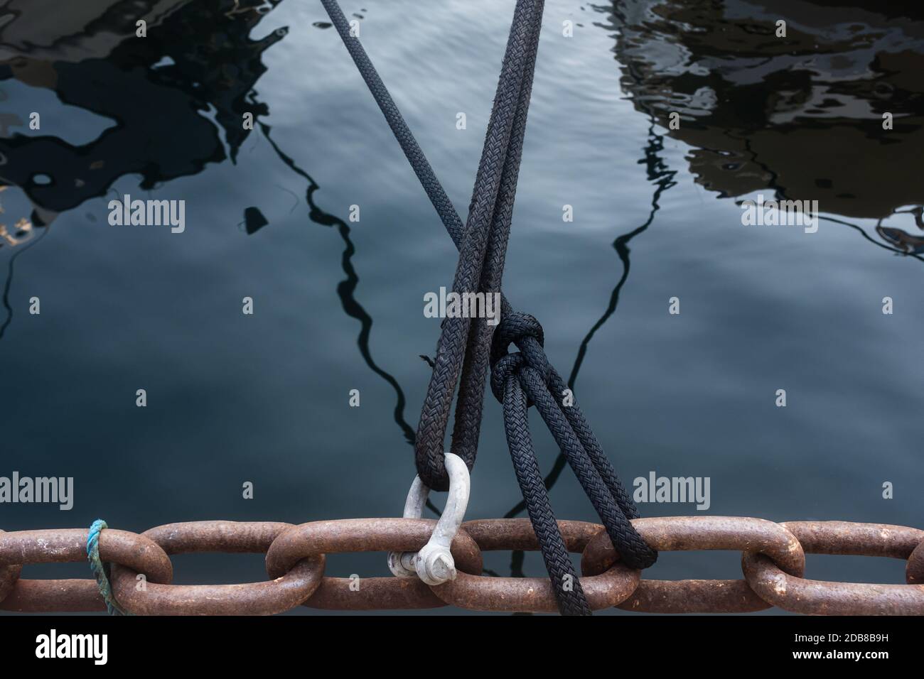 Detail of two mooring ropes crossing before tightening to a large chain ...