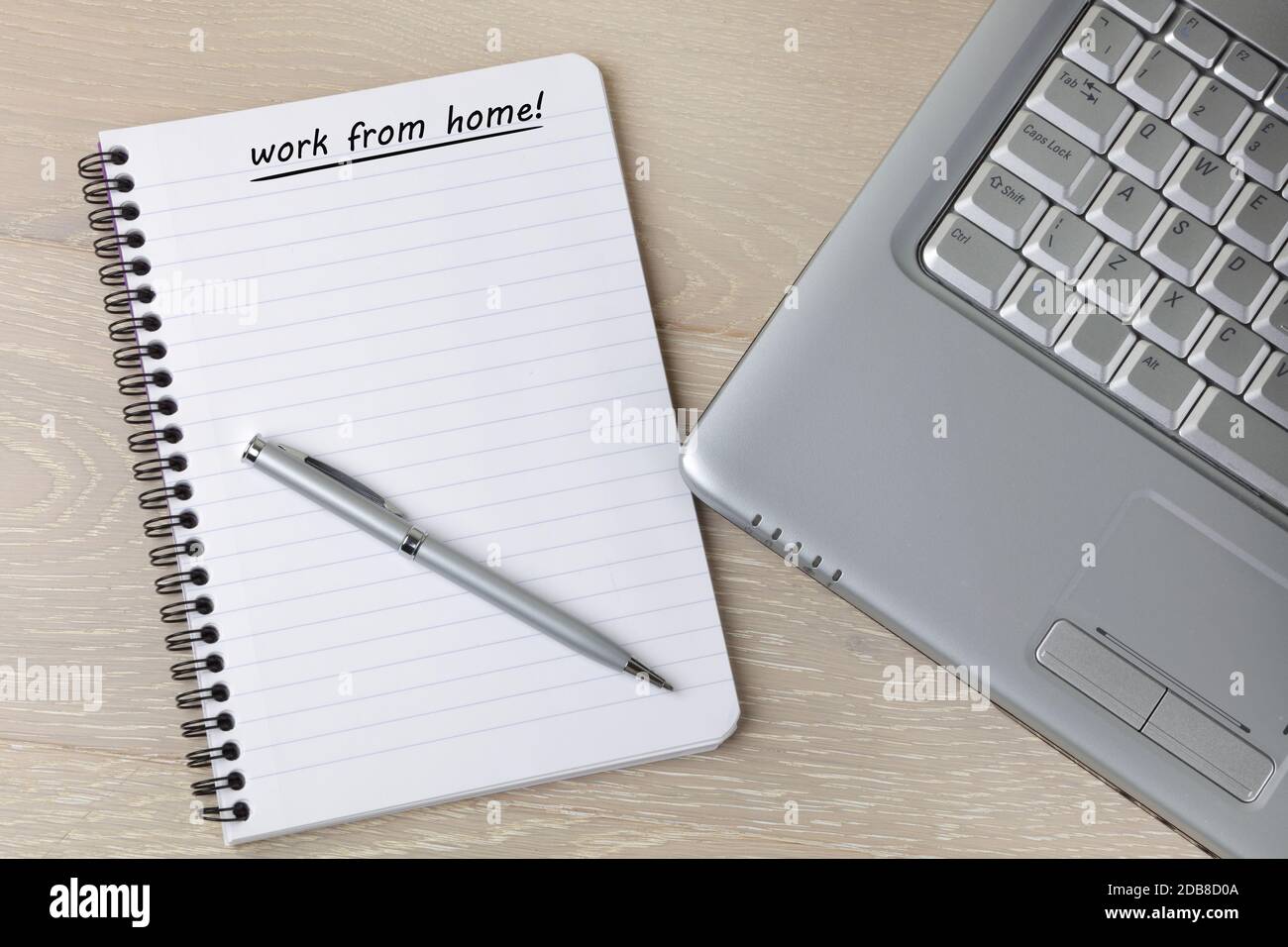 A pad pen and laptop on desk with work from home reminder Stock Photo ...