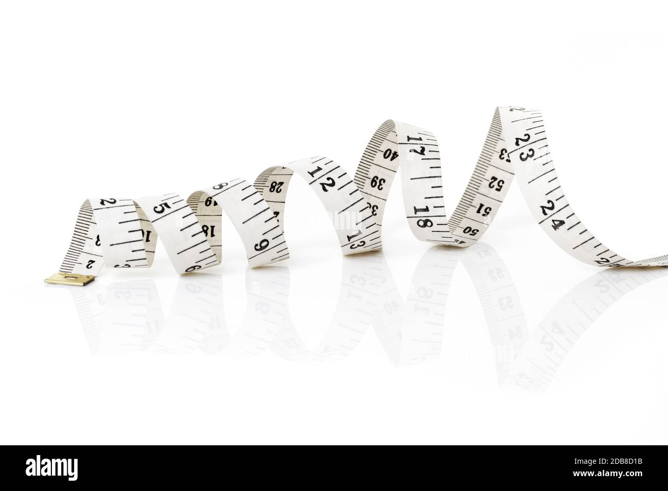 An unrolled white tape measure on white surface with reflection inch ...