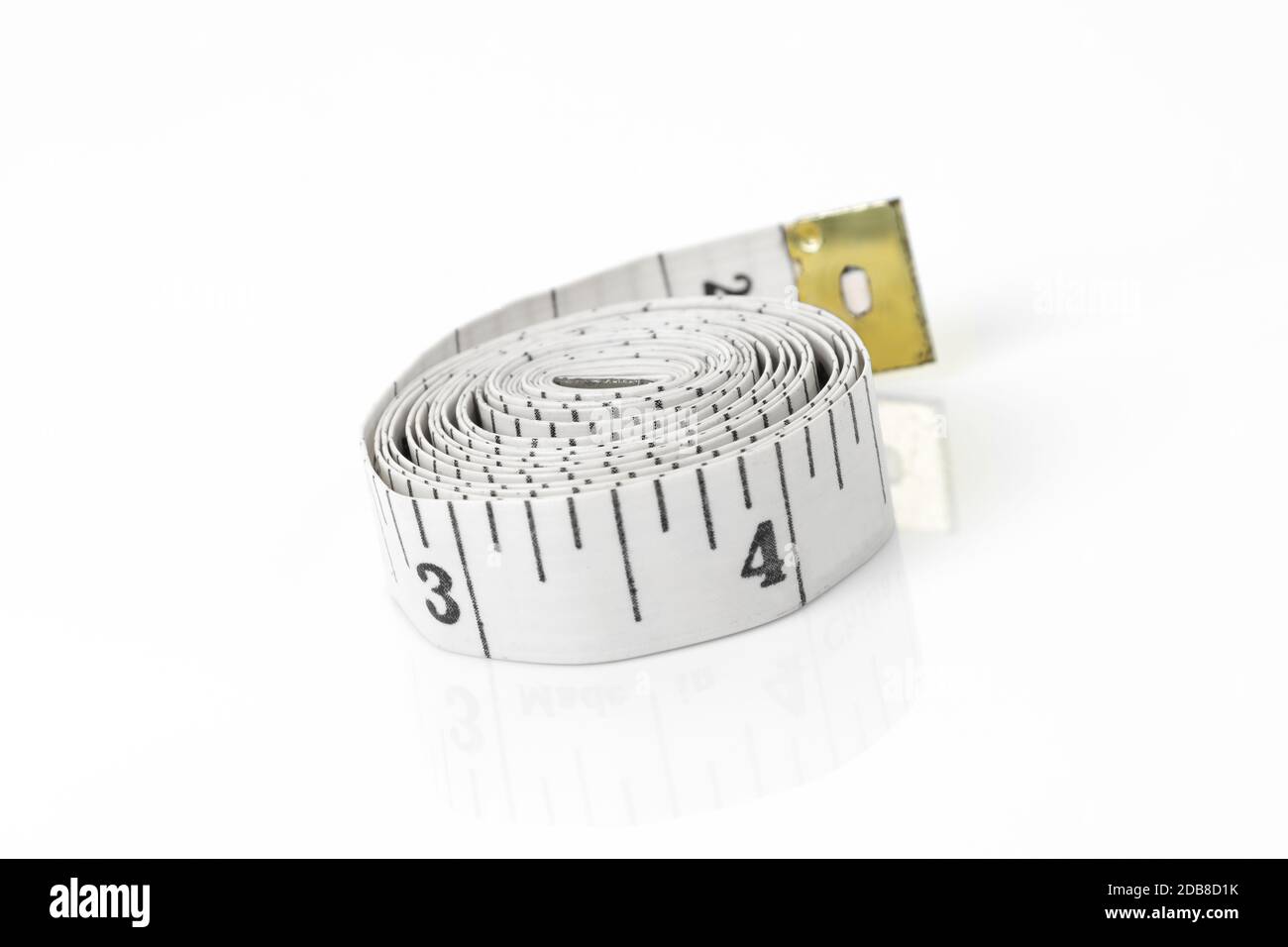 A white tape measure rolled up on white inches Stock Photo - Alamy