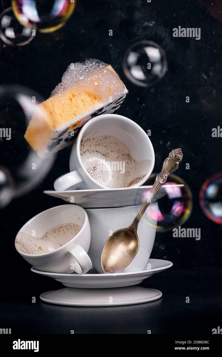 Washing coffee cups with a washcloth with foam, conceptual photo with ...