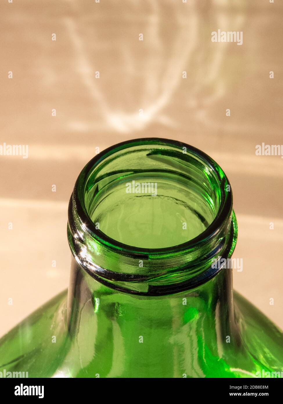 Bottleneck of green bottle in close up, with defocused light background ...