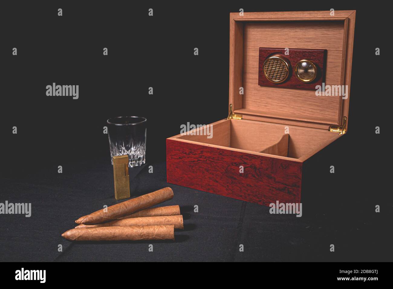 Cigar box on black background and gold lighter Stock Photo - Alamy