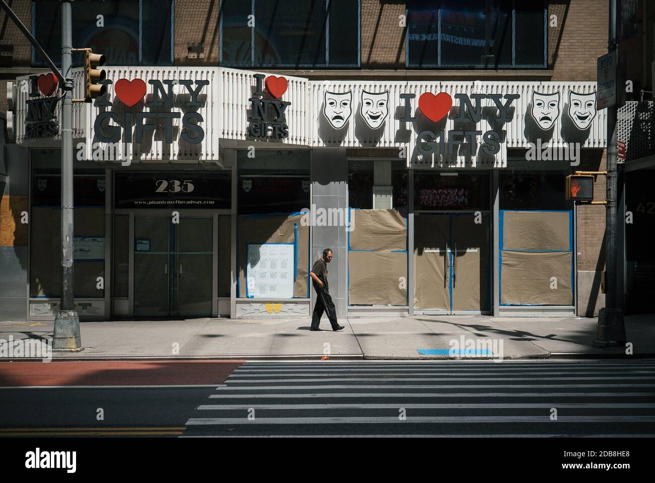 A homeless man walks in front of a closed gift store on 42nd street ...