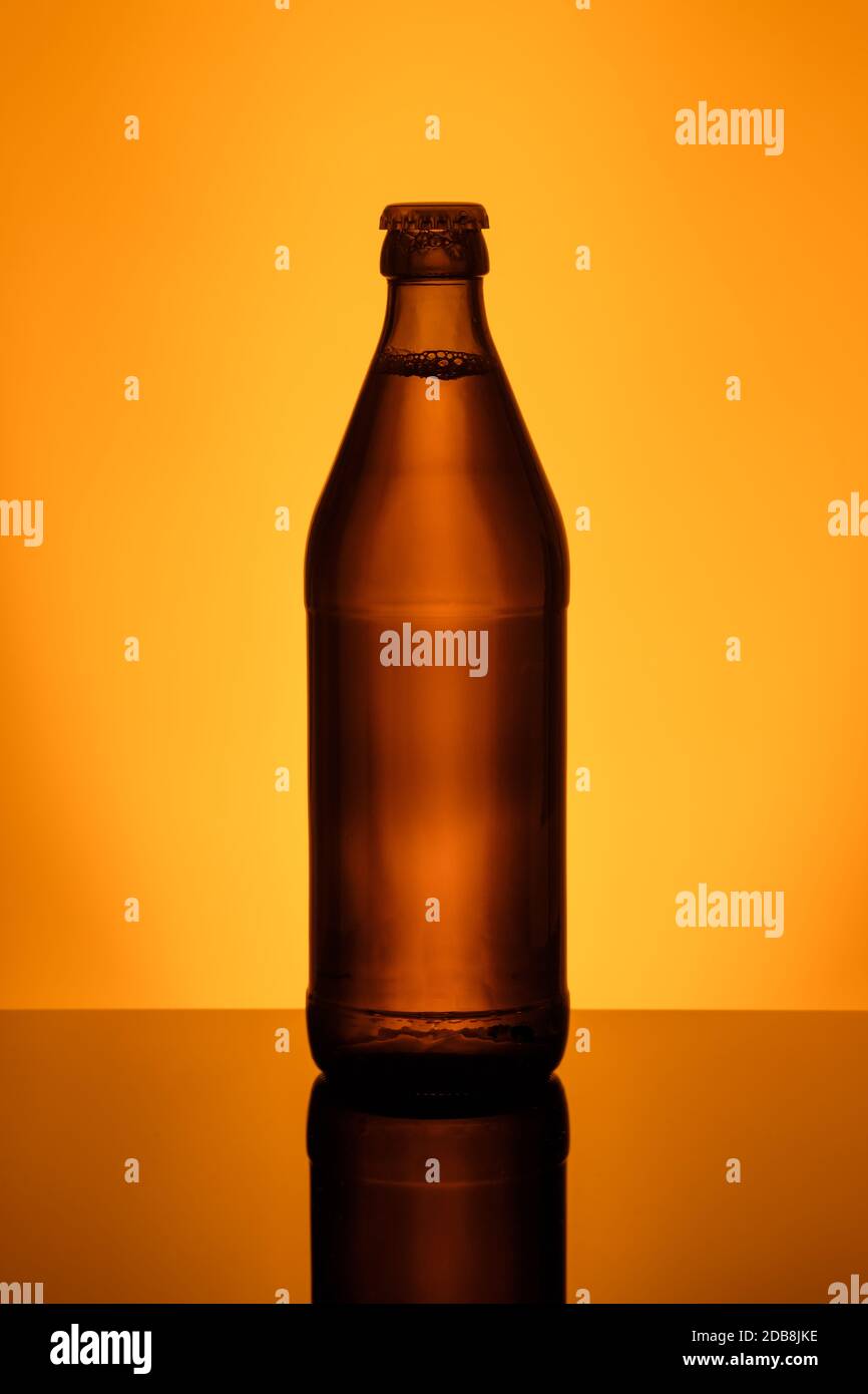 Beer bootle with crown cap in back lit in vertical format Stock Photo ...