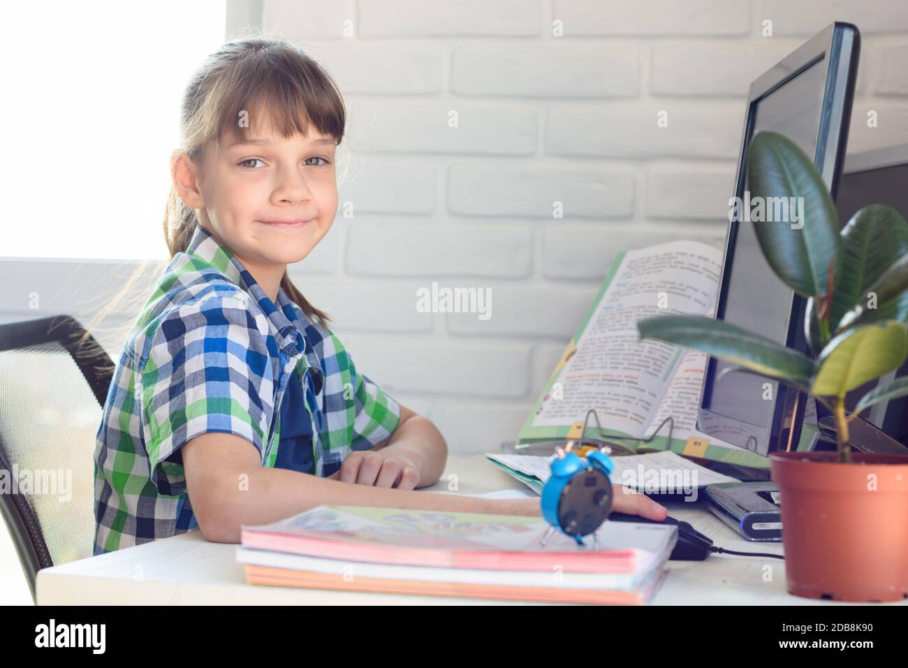 The girl does homework at the table, looked into the frame Stock Photo ...