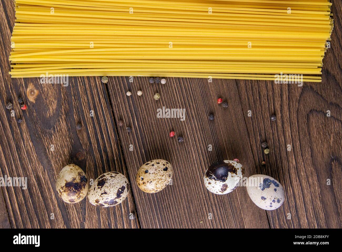 Quail eggs and spaghetti pasta wooden table. Top views with clear space ...