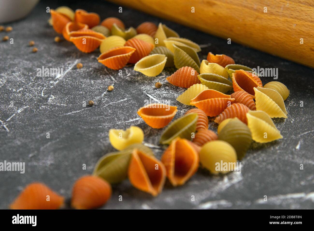 Pasta Conchiglie Rigate, mix of colorful uncooked shells with rocking ...