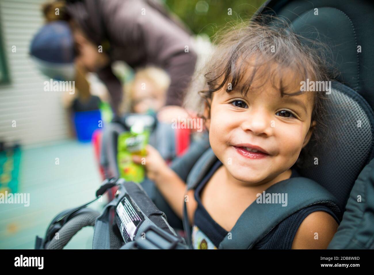 Happy baby in a backpack carrier Stock Photo - Alamy