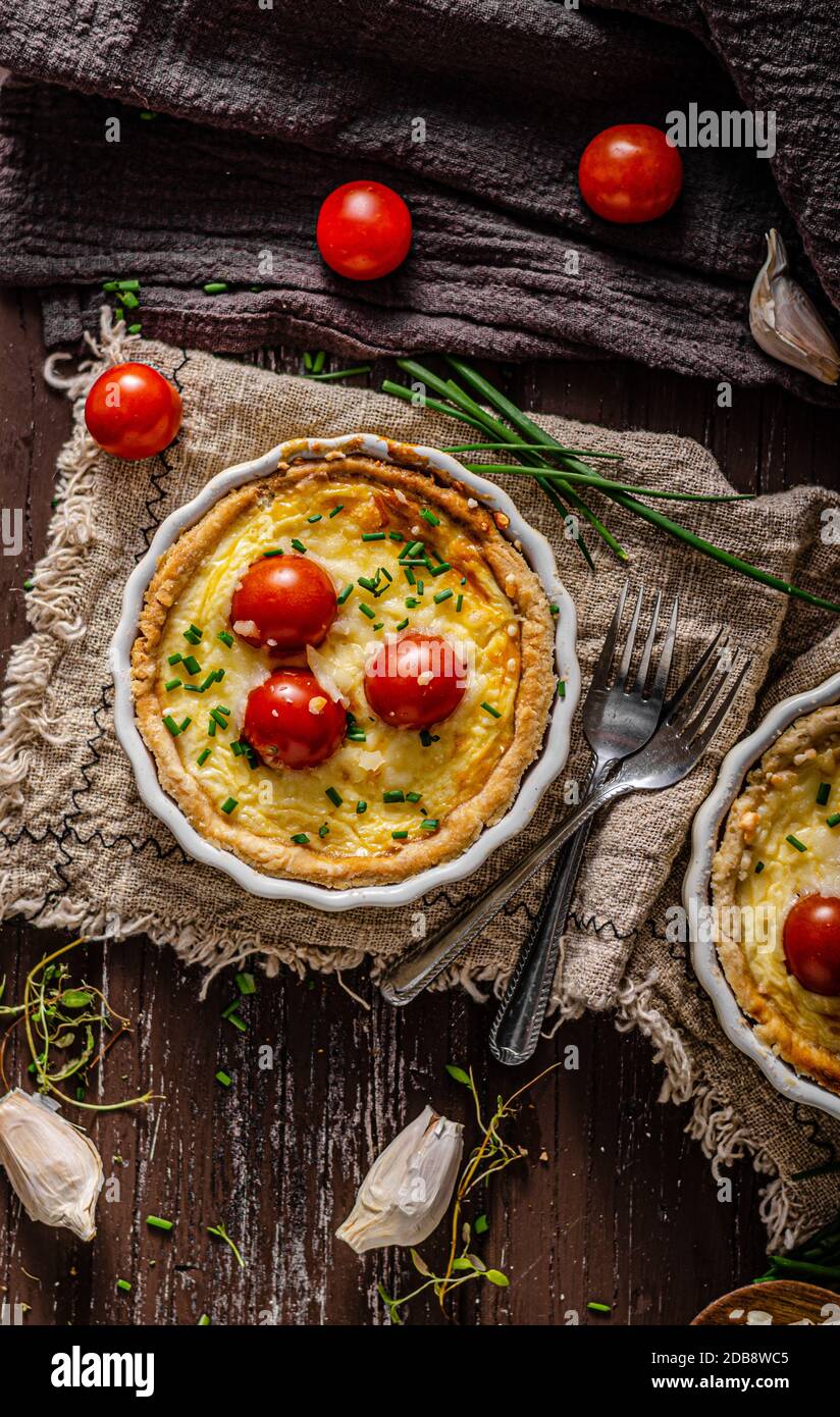 Rustic cheese quiche with bio cocktail tomatoes Stock Photo - Alamy