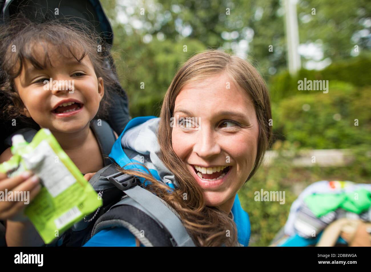 An adventurous mother hikes with her daughter in her backpack Stock ...
