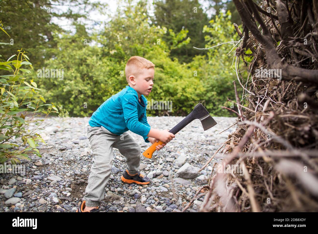 Toddler uses an axe to chop wood Stock Photo - Alamy