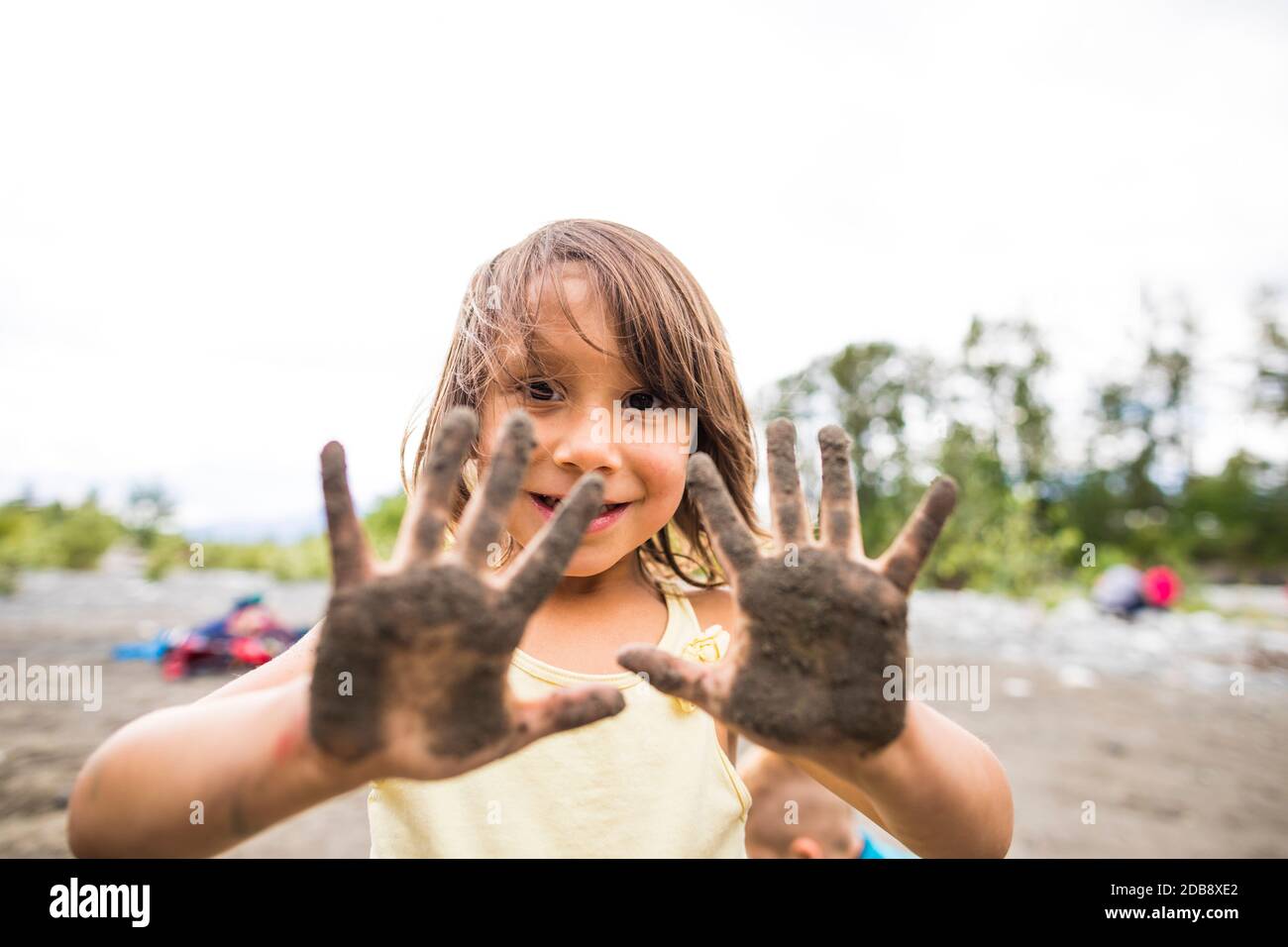 Young girl shows her muddy / sandy hands Stock Photo - Alamy