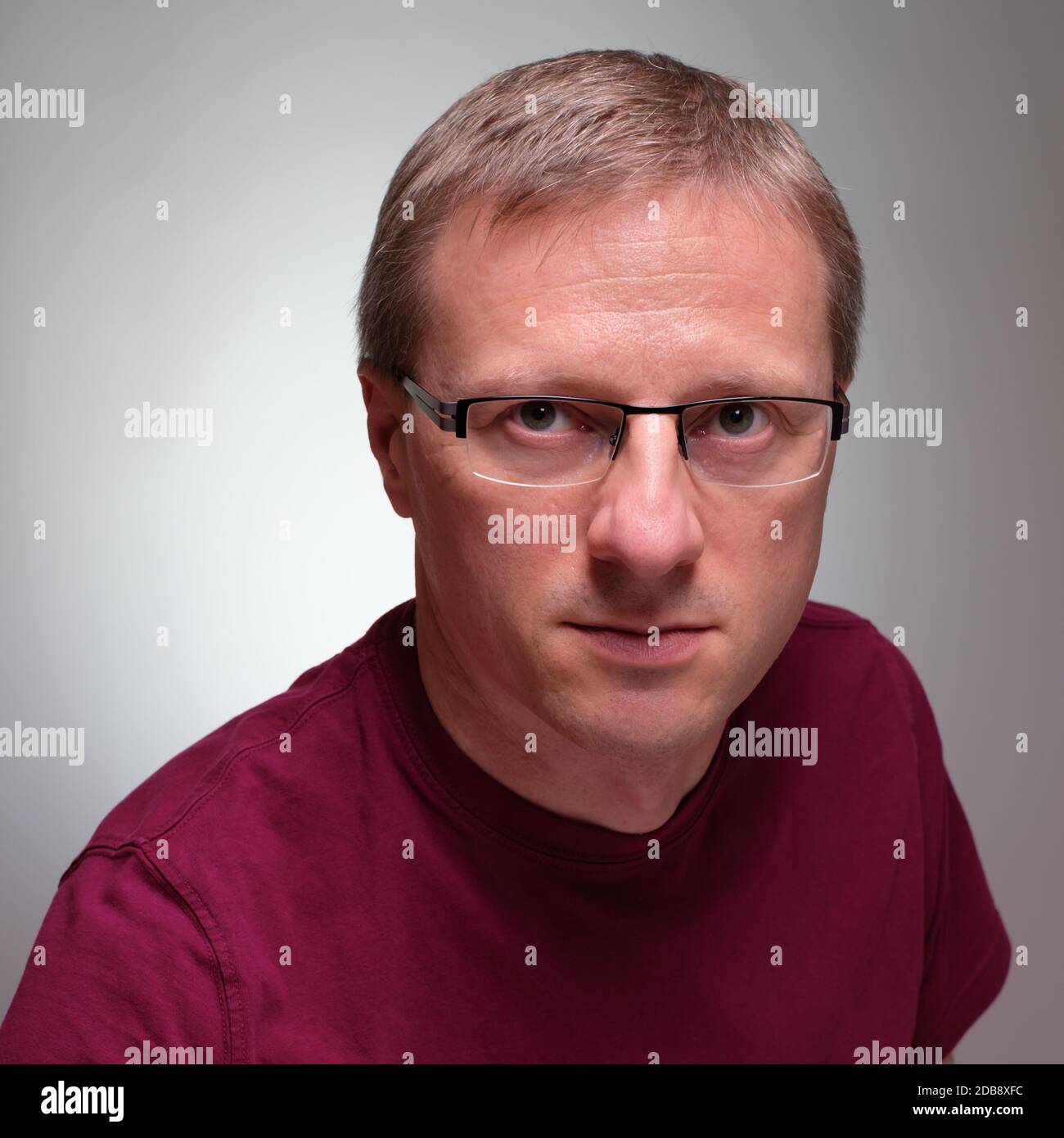 Man with glasses and skeptical glimpse background grey Stock Photo - Alamy