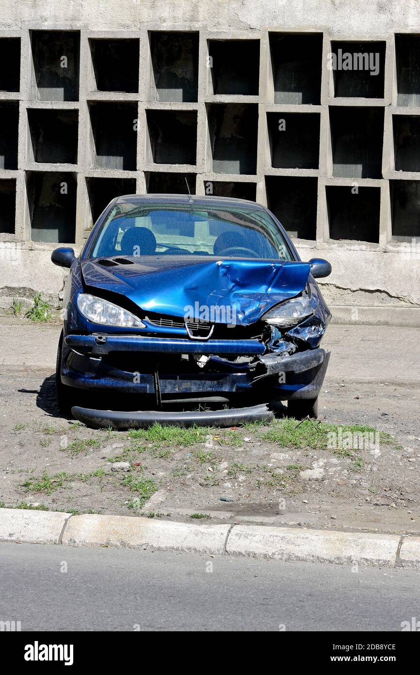 Small blue car smashed in traffic accident Stock Photo - Alamy