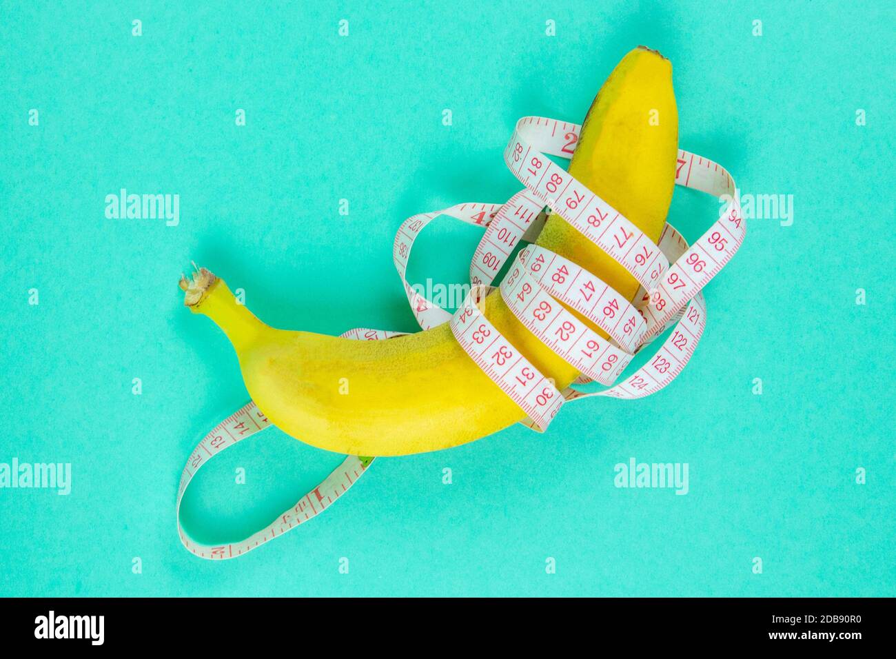 Banana with tape for measuring figure. Centimeter ruler spinned around ...