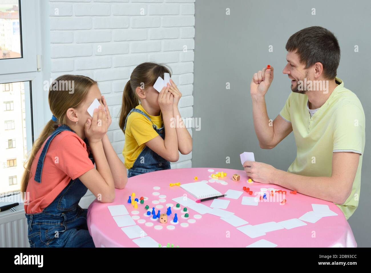 Dad and daughters play board games at home Stock Photo - Alamy