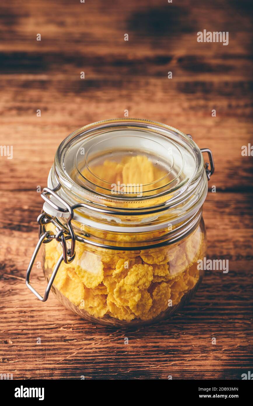 Corn flakes in a glass jar on wooden surface Stock Photo - Alamy