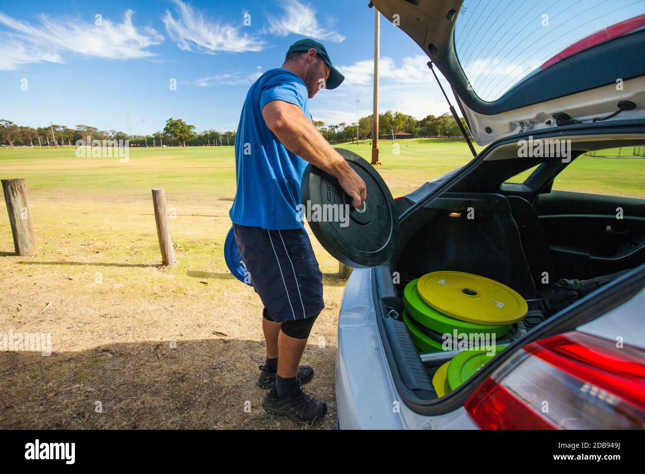 Man loading weights into car after workout Stock Photo - Alamy