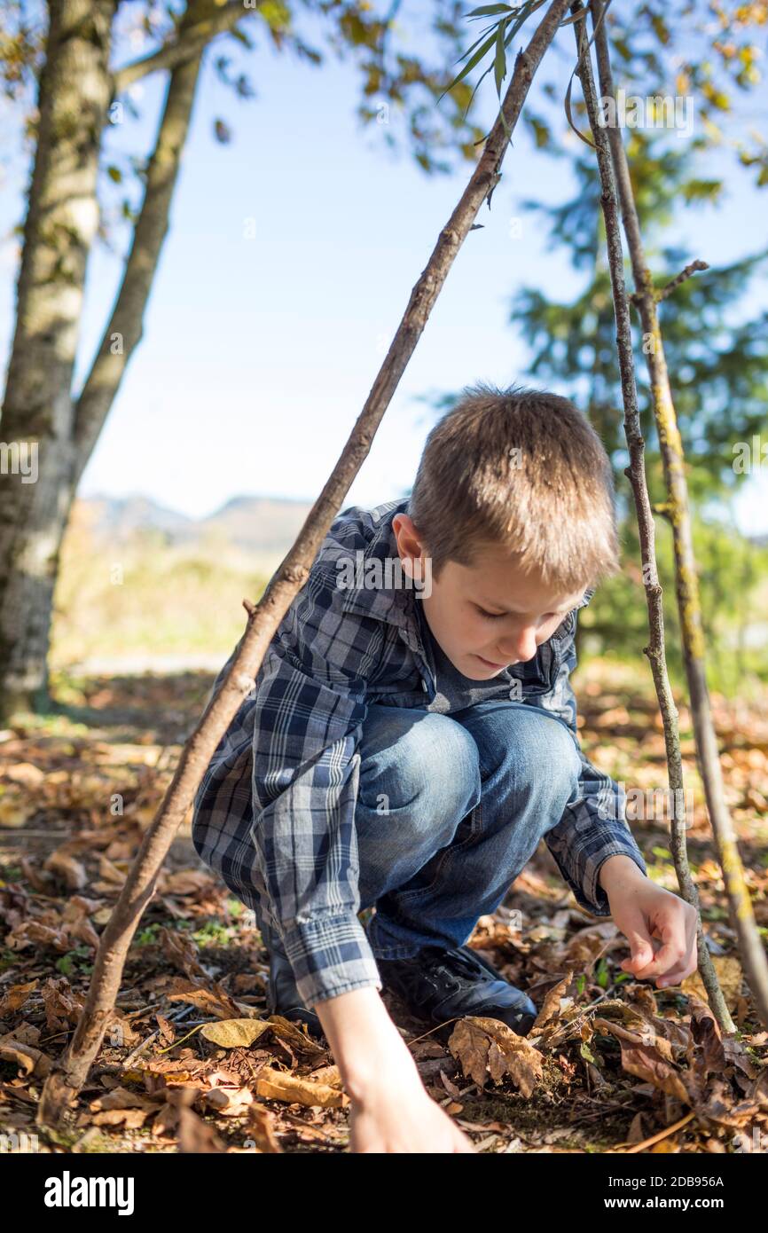 Young boy stands under a tee-pee structure outdoors Stock Photo - Alamy
