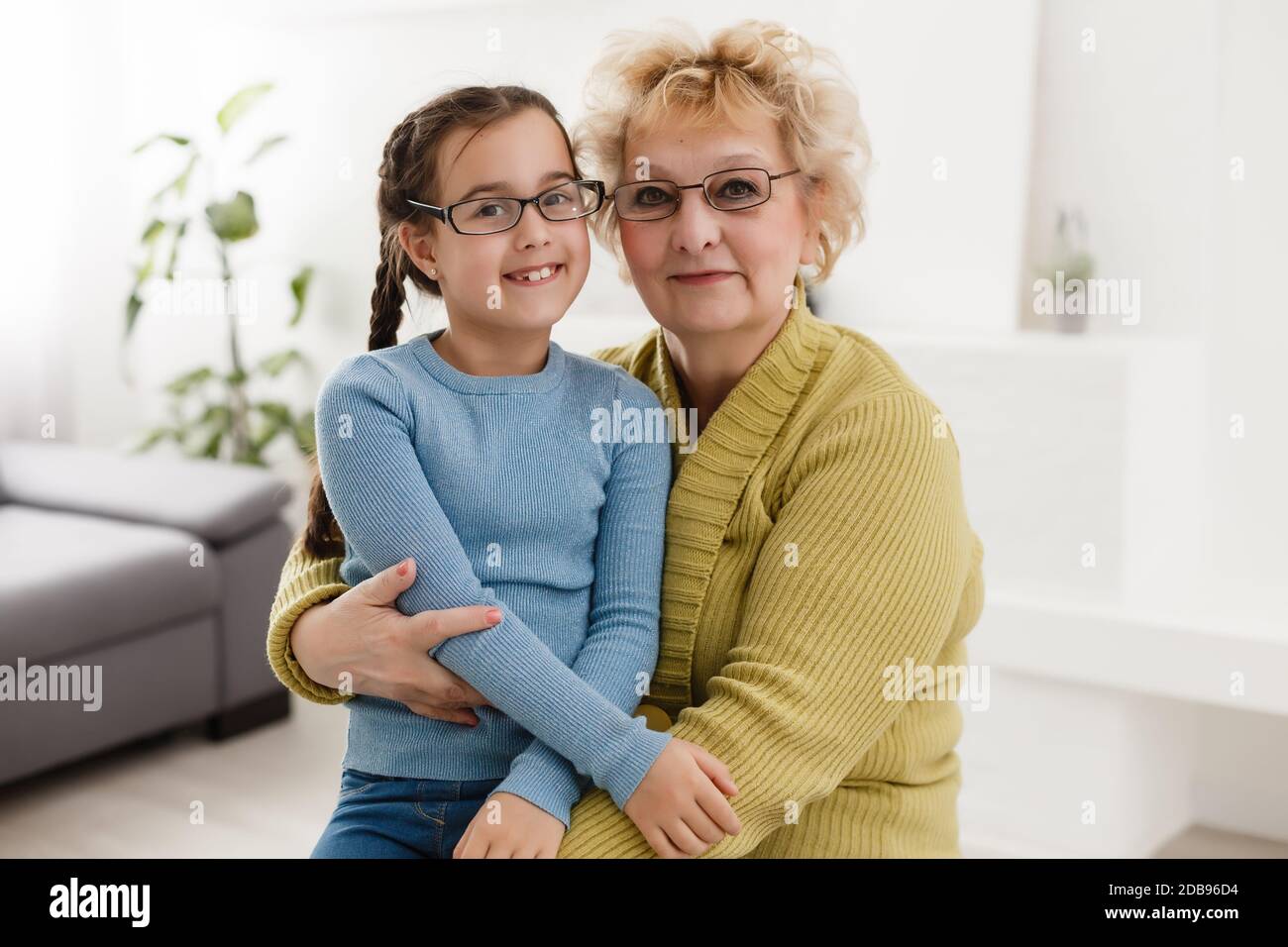 Portrait of happy old grandmother and kid girl looking at camera ...
