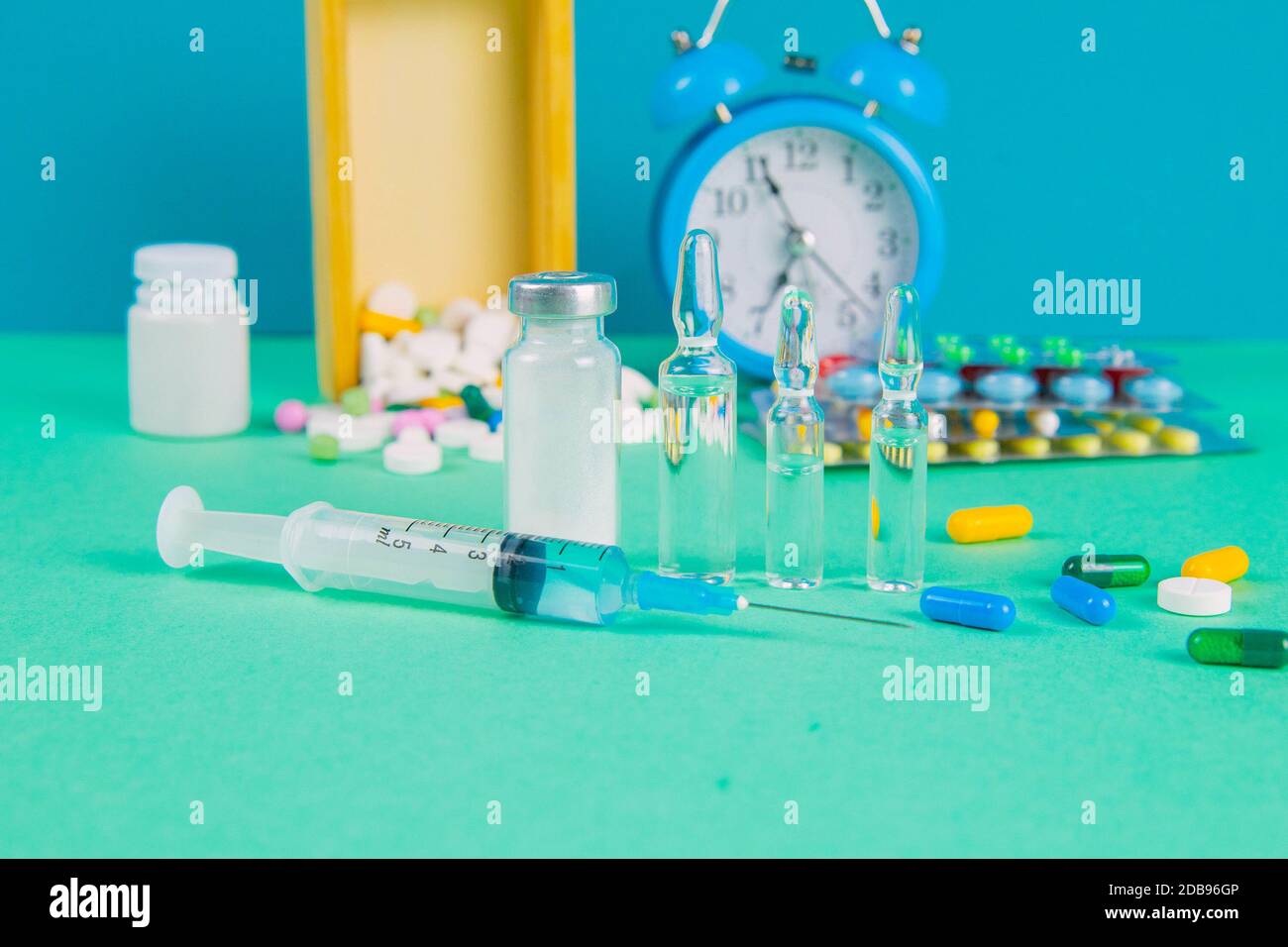 Syringe with glass vials and medications pills drug. In the background ...