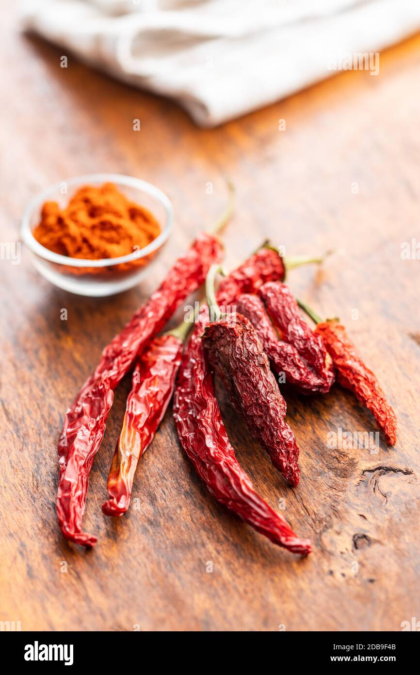 Dried red chili peppers and chili powder spice on wooden table Stock ...