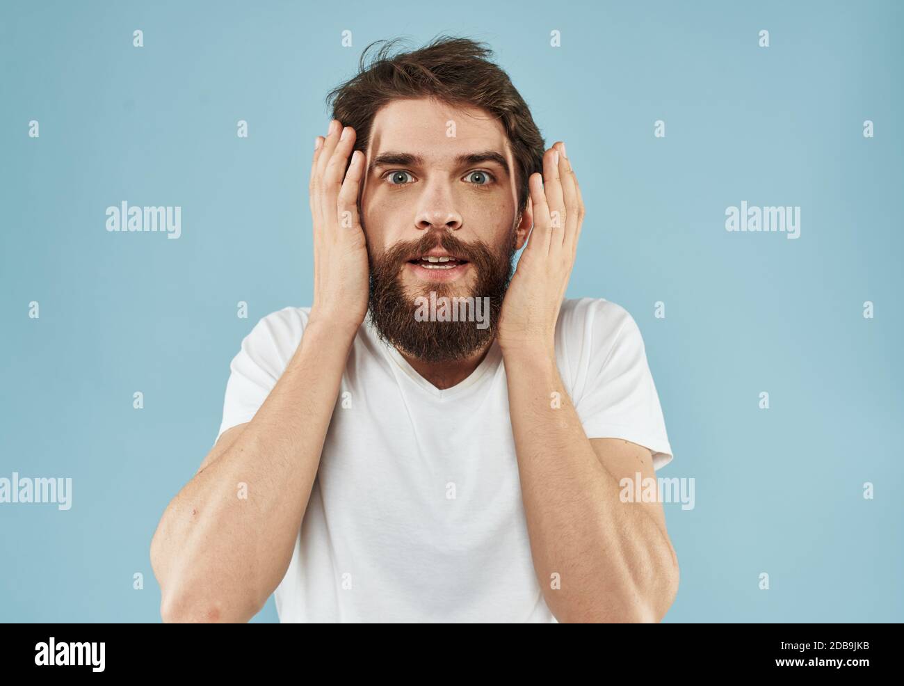 Puzzled man with a beard on a blue background emotions of surprise ...