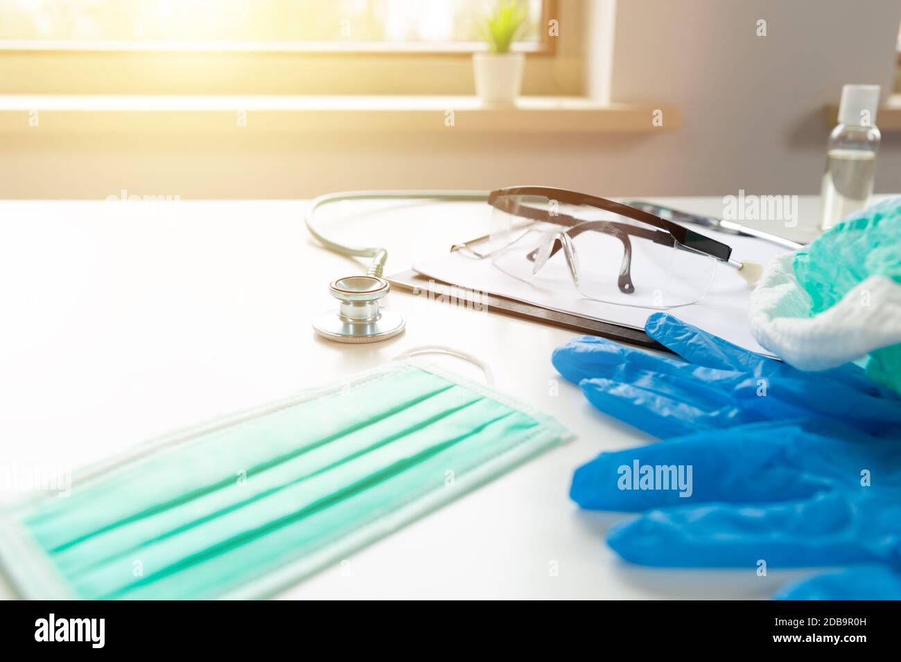 Doctors and nurses protection kit on a white table with sunny window ...