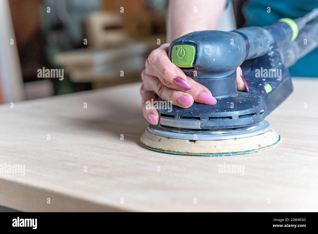 sanding wooden furniture using an electric hand grinder Stock Photo - Alamy