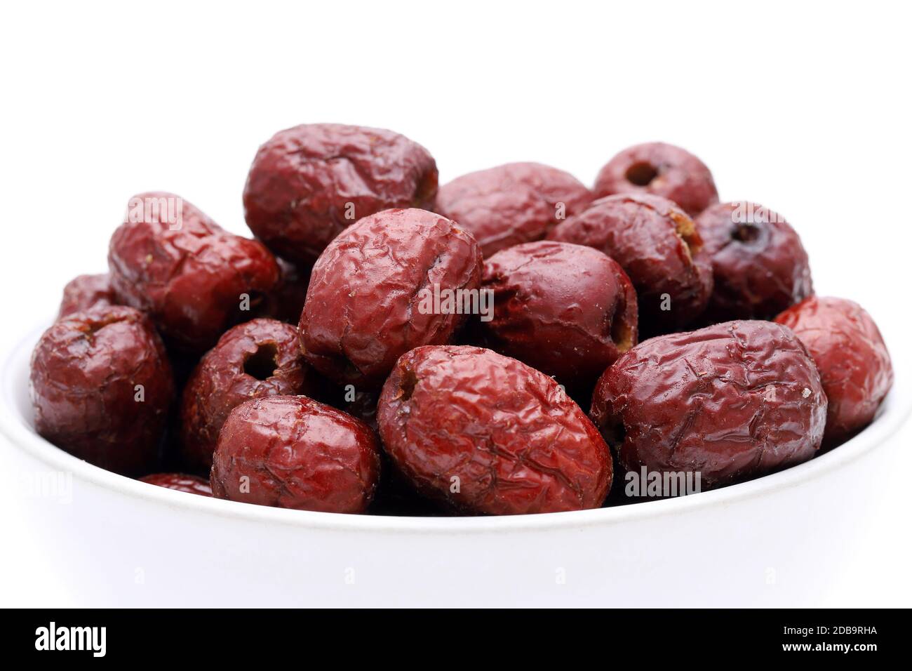 Jujube, Chinese dried red date fruits in a bowl on white background ...
