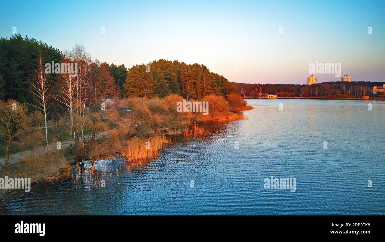 Lakeside with colorful trees in spring sunlight. April evening at the ...