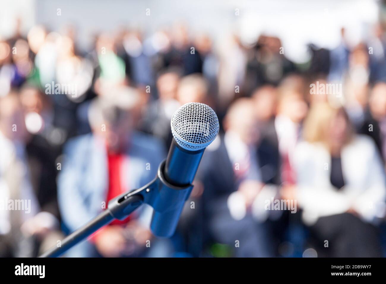 Microphone in focus against blurred audience Stock Photo - Alamy