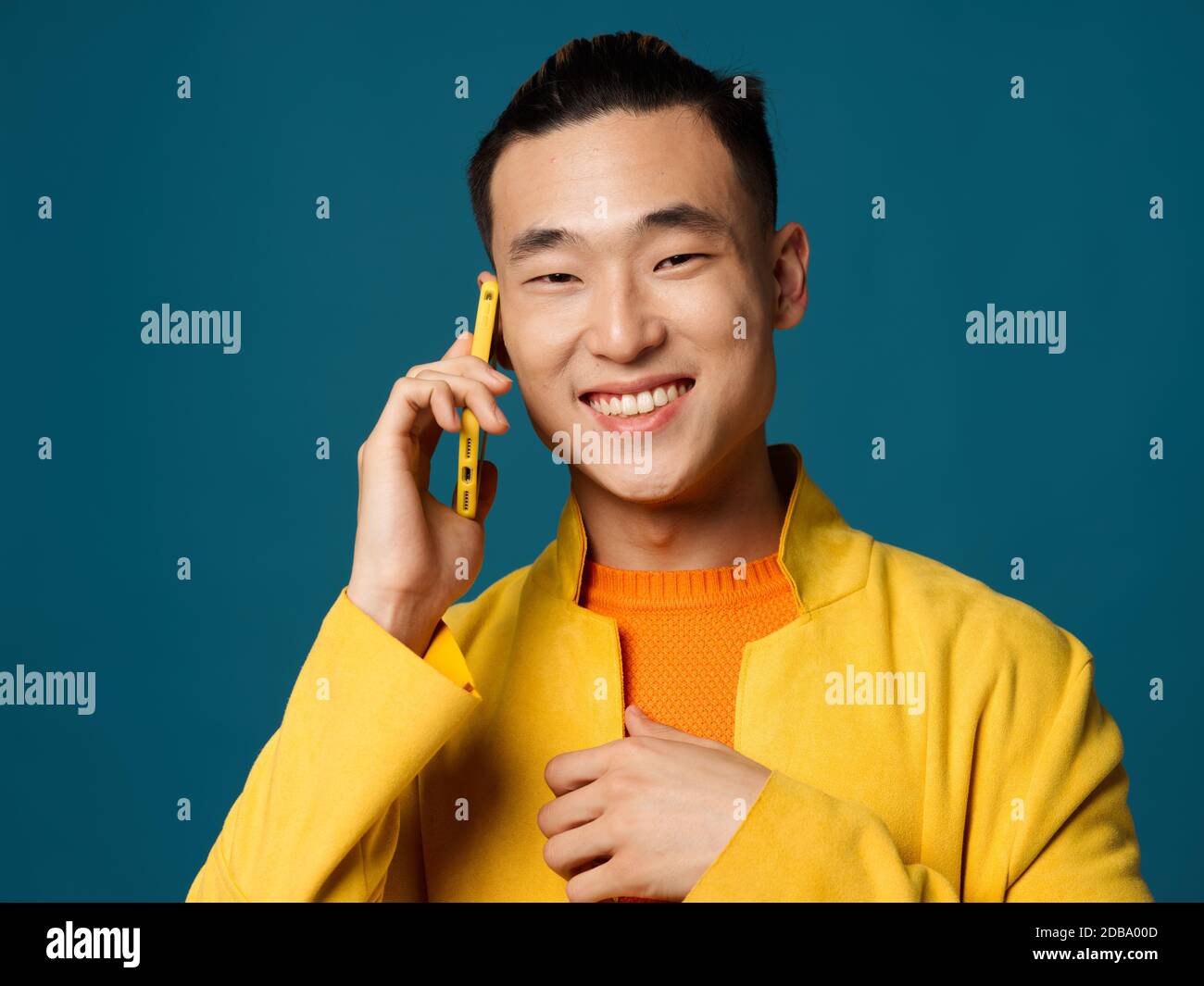 Happy male asian appearance korean blue background mobile phone Stock ...