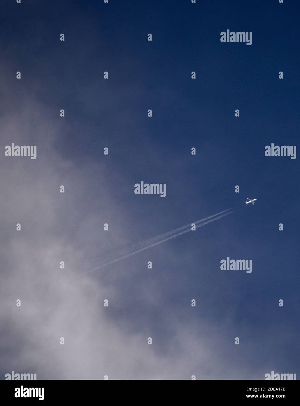 A commercial passenger jet leaves a contrail in its wake as it flies ...