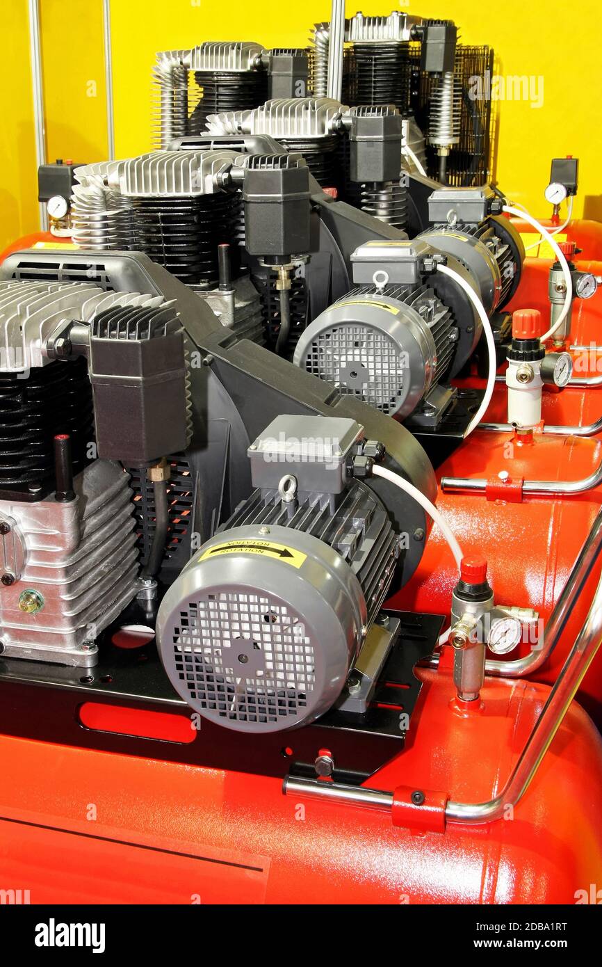 Several red powerful air compressors in line Stock Photo - Alamy