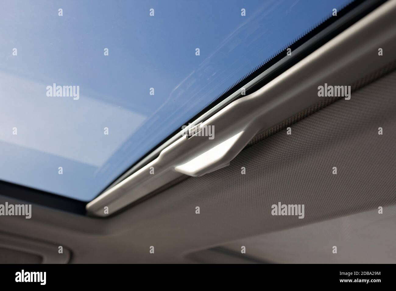 View through open sunroof of blue sky. Enjoy nature from car concept ...