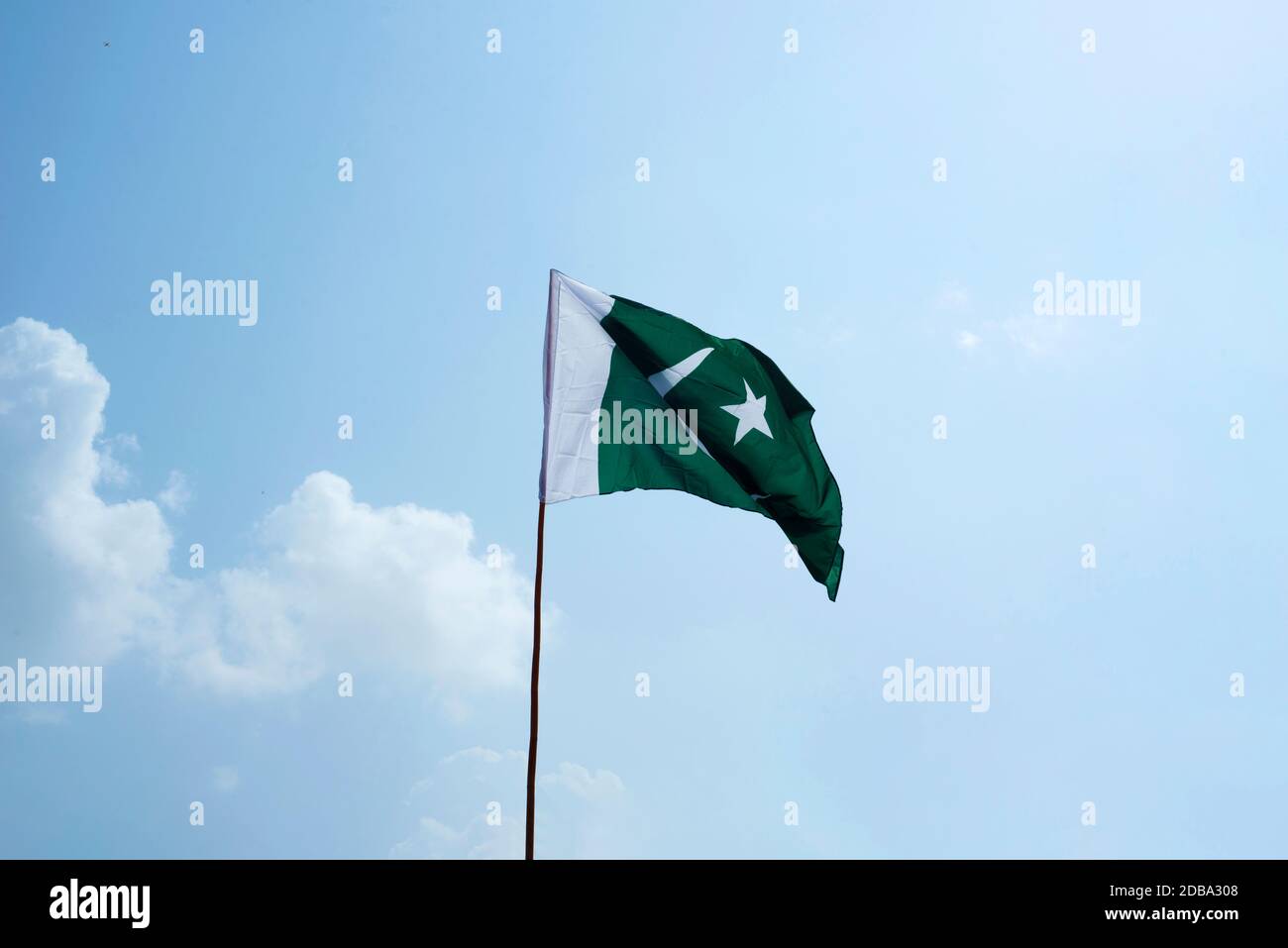 The national flag of Pakistan flying in the blue sky with clouds Stock ...