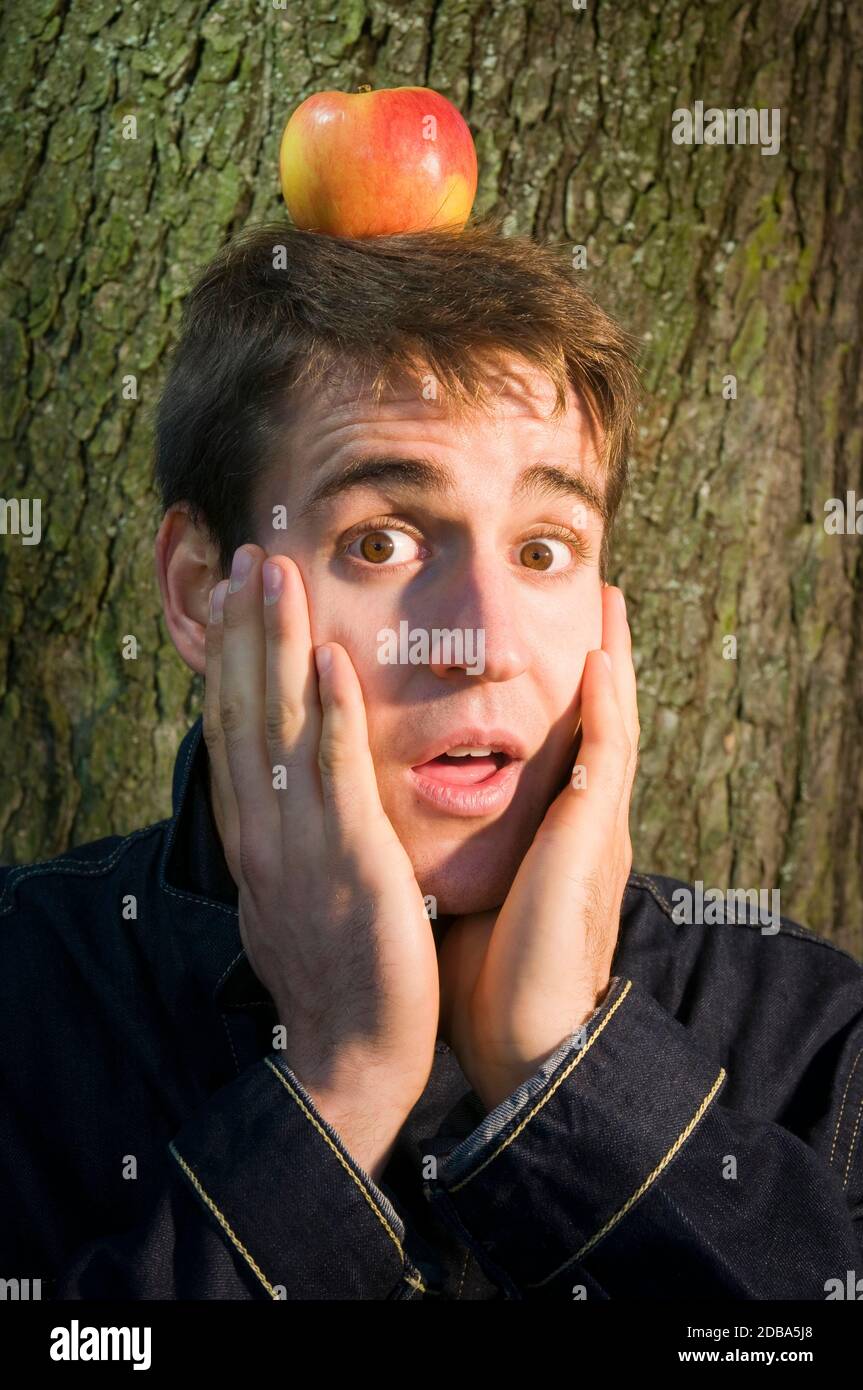 Frontal head-and-shoulders view of a young man with an apple on his ...
