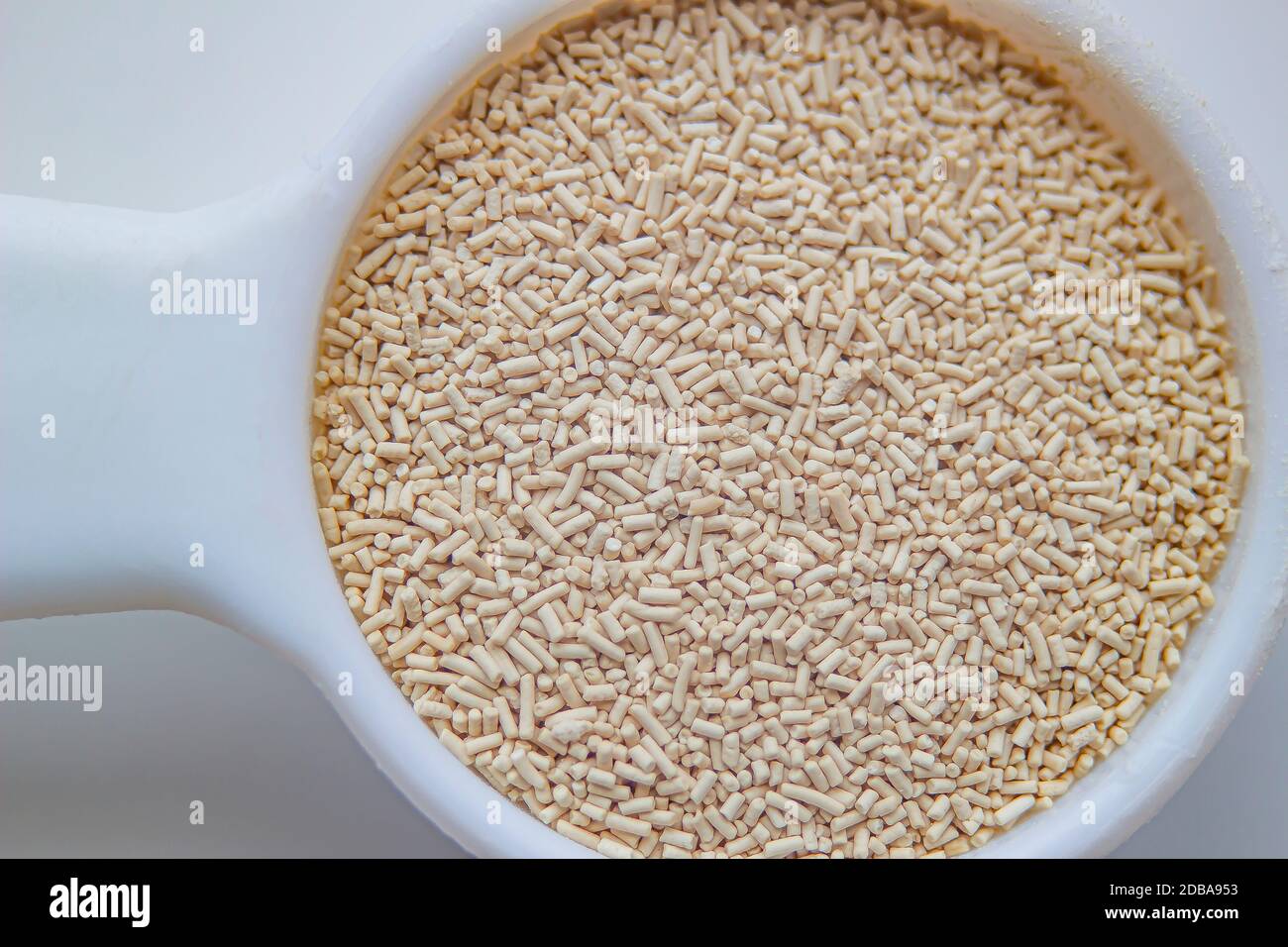 A top view close up of a measurement baking spoons with yeast on a ...