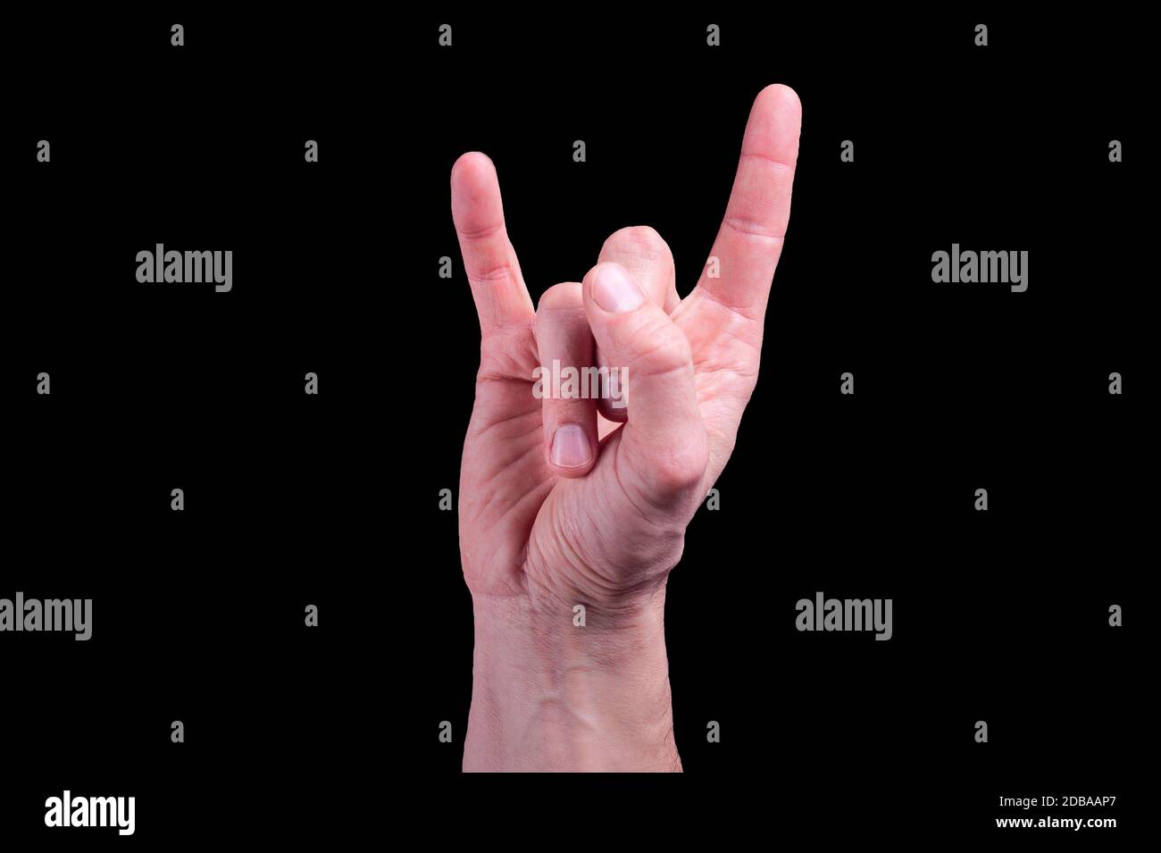 Hand of euroopean human shows the sign of the horns on isolated black ...