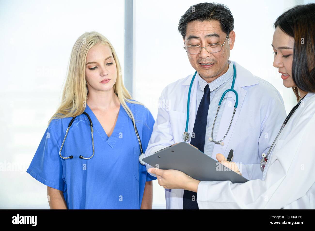Group of doctors wearing formal white coat and blue scrubs suit ...