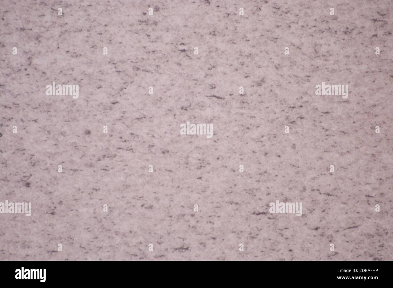 Pale rose quartz interspersed with black flat polished surface close-up ...