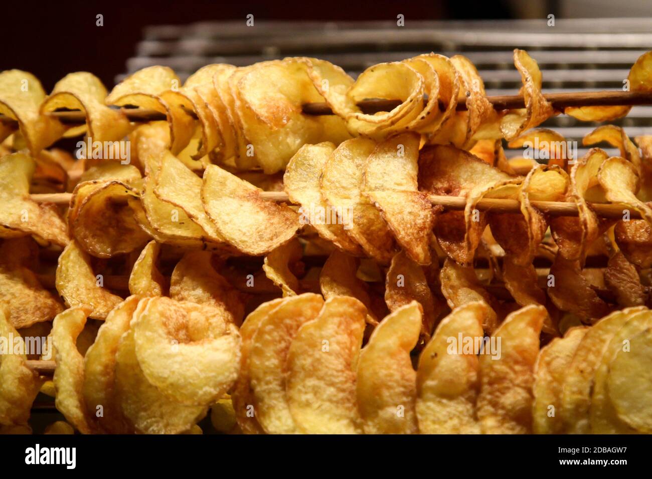 Twisted potato chips on a wooden skewer Stock Photo - Alamy
