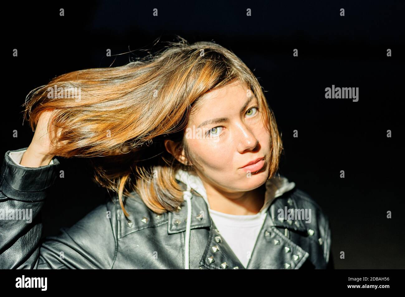 very beautiful young girl in a black jacket raised her hair up Stock ...