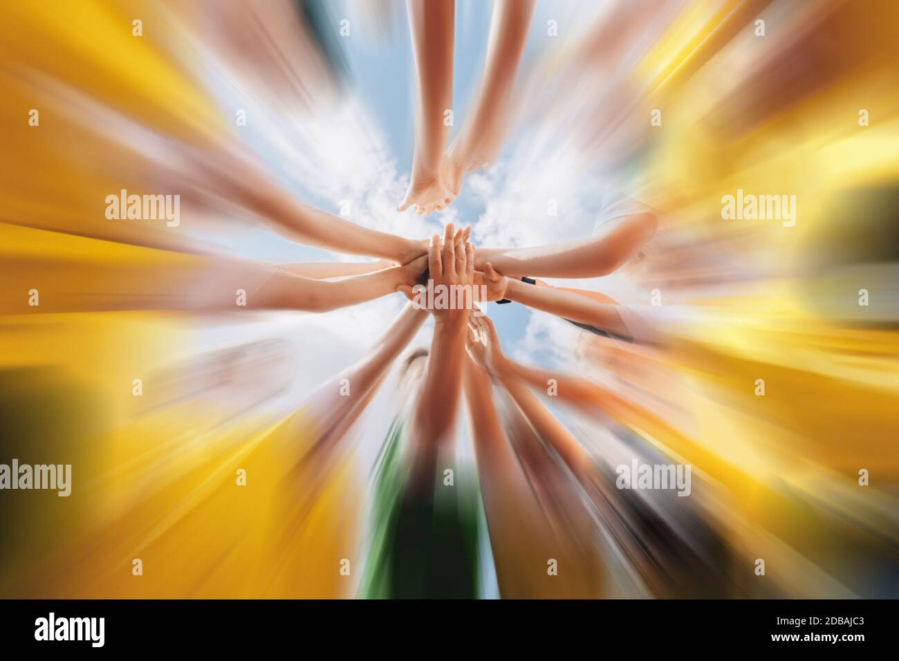 Low angle shot of a group of sports team forming a huddle with their ...